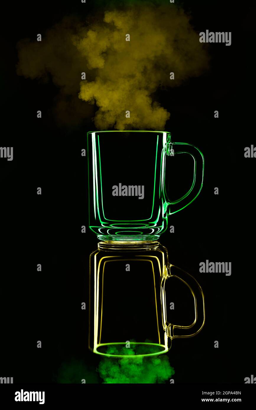 Just a glass on a black background with a reflection. Yellow and green ...
