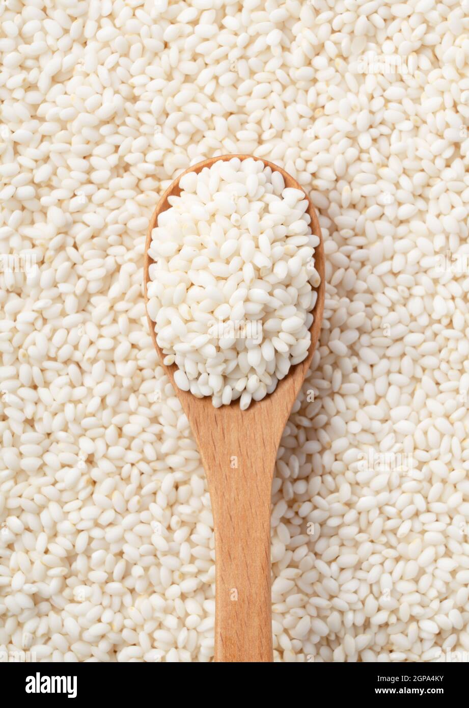 A wooden spoon is placed on top of the glutinous rice spread across the ...