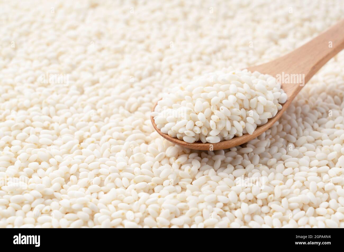 A wooden spoon on top of glutinous rice spread over the entire screen ...