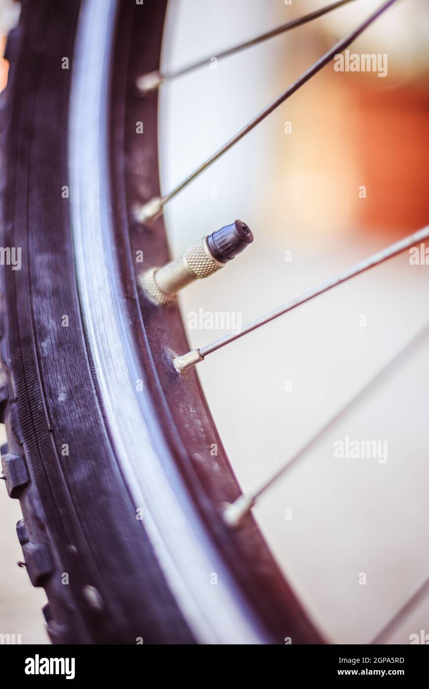Close up picture of a bike tyre outlet and spokes, blurry background ...