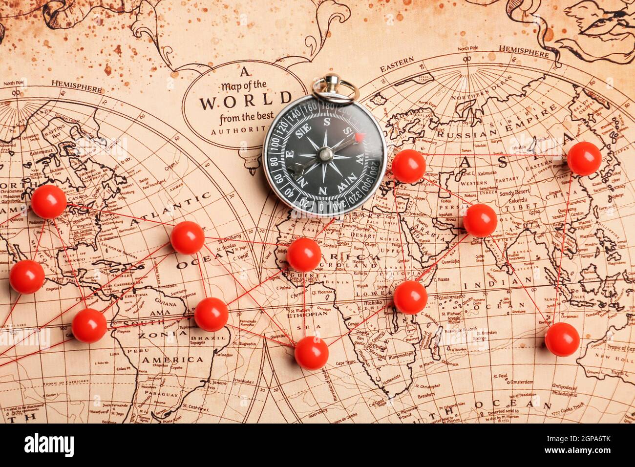World map with pins and compass, closeup Stock Photo - Alamy