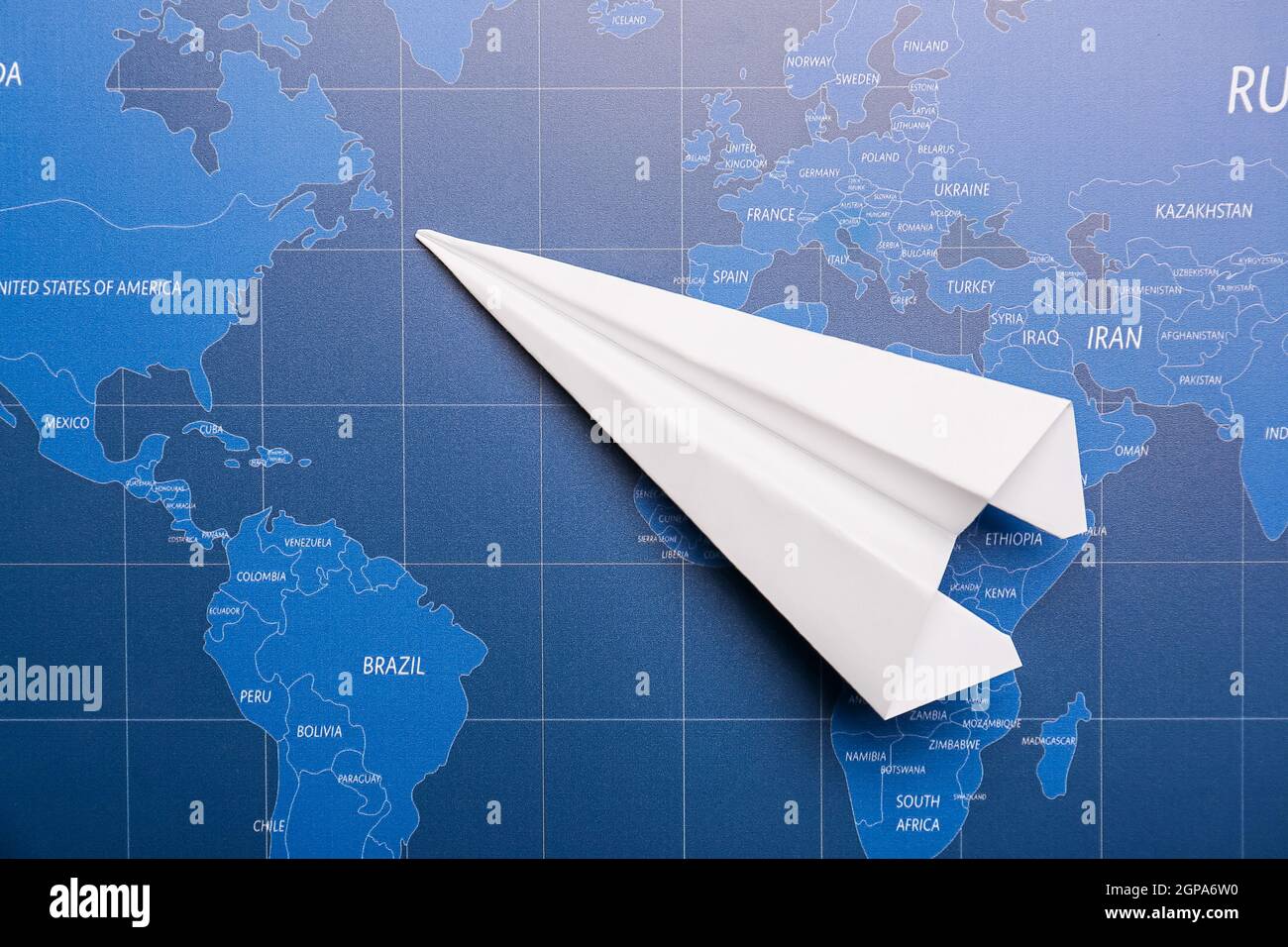 Paper airplane on world map Stock Photo - Alamy