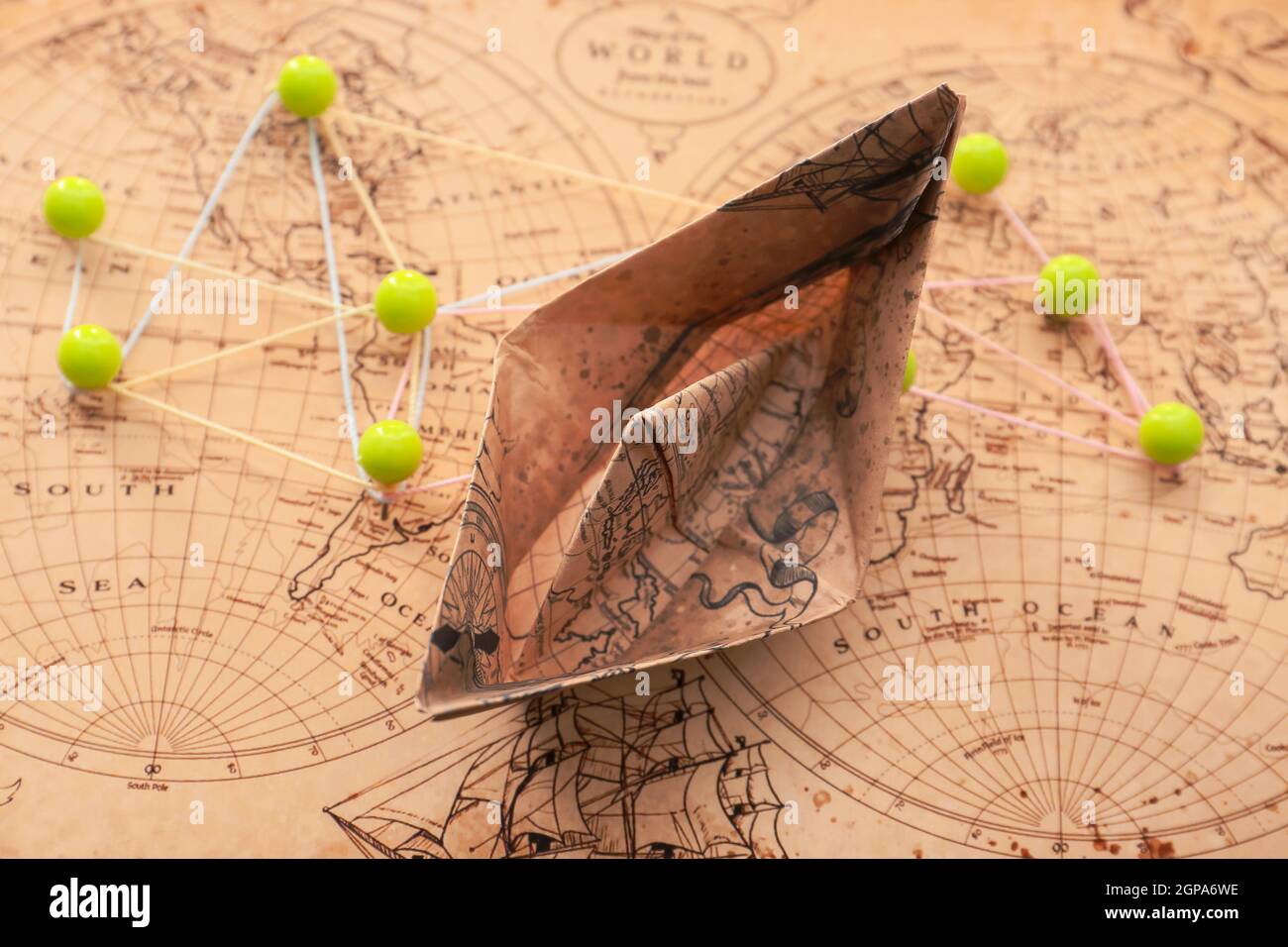 Paper boat, world map and pins, closeup Stock Photo - Alamy