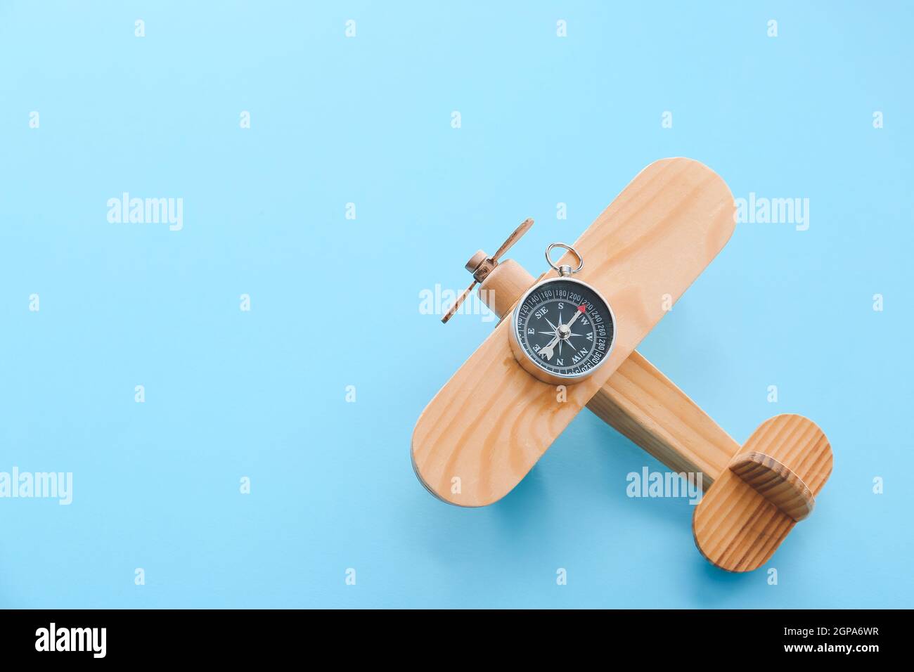 Wooden airplane and compass on color background Stock Photo - Alamy