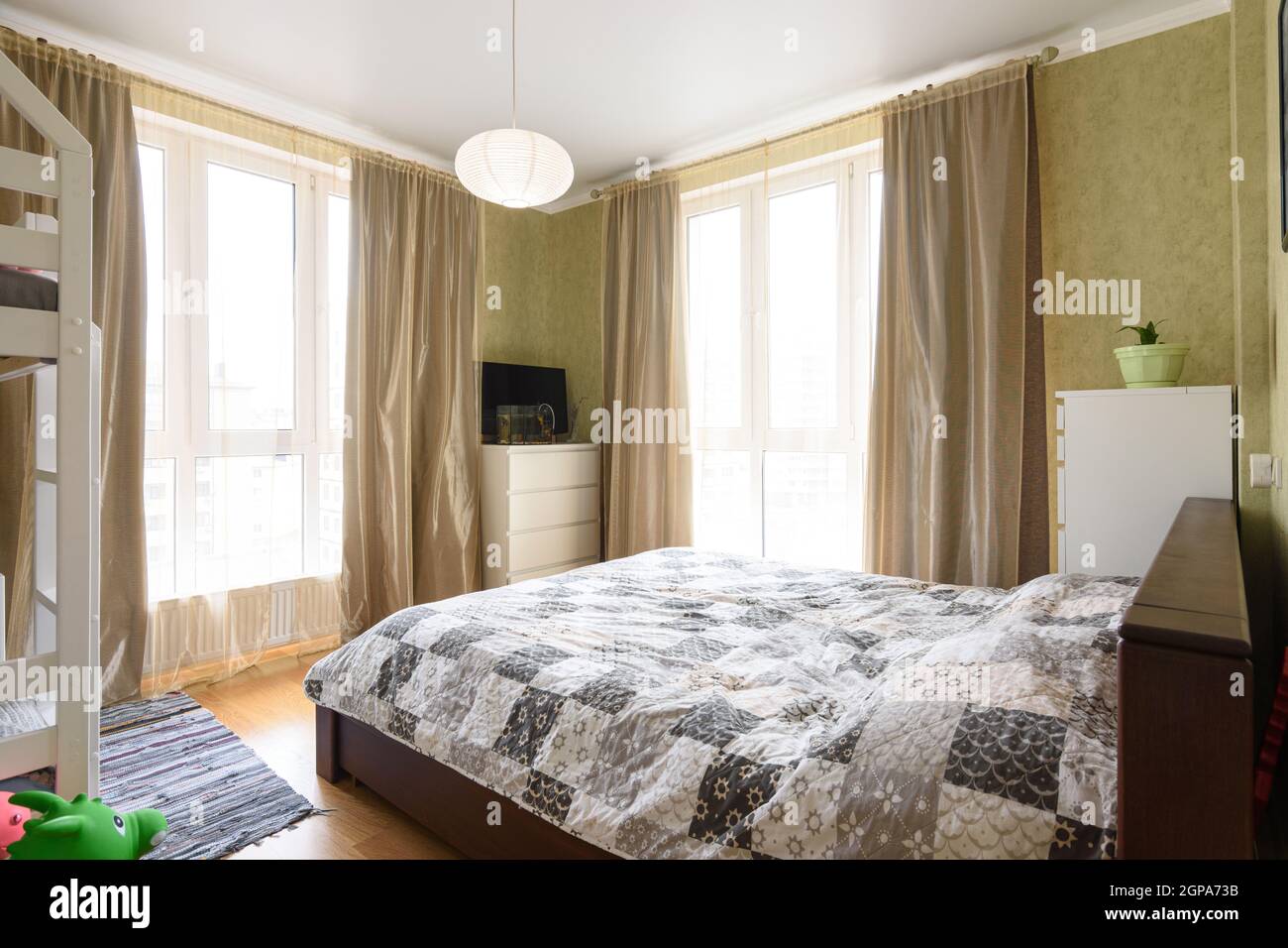 Interior of a bright bedroom with a large double bed and two large ...