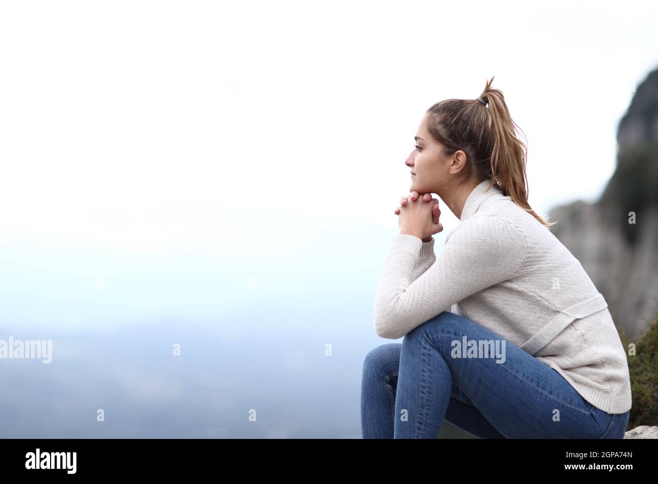 Side view portrait of a happy woman contemplating views in the mountain ...