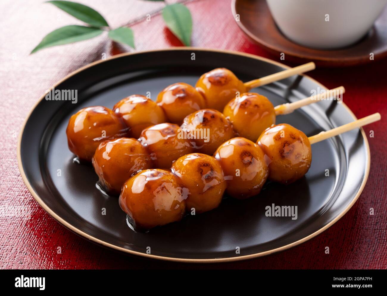 Mitarashi dango and green tea on a red Japanese tray. Image of ...
