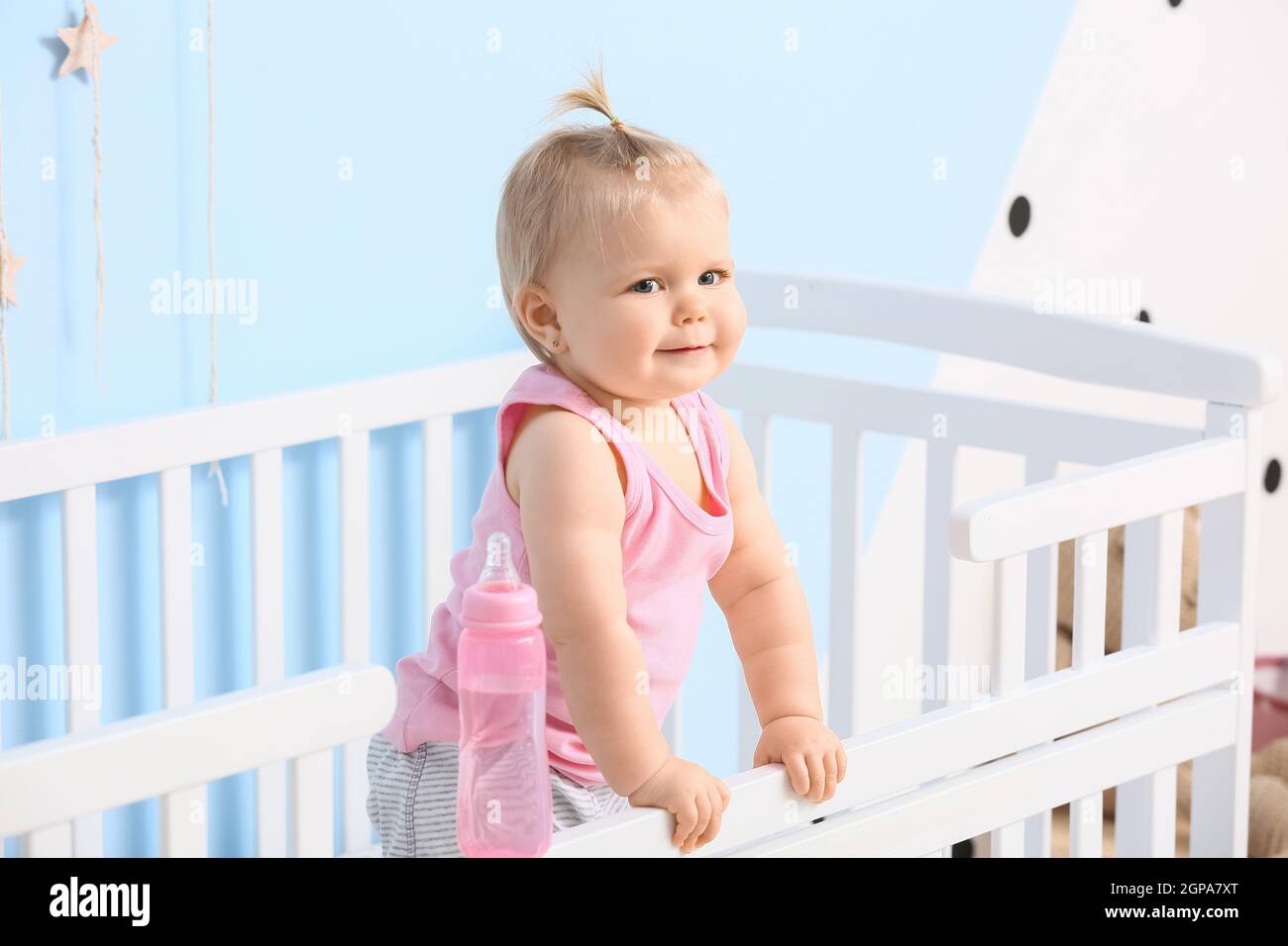 Cute baby girl with bottle of water in cot Stock Photo - Alamy