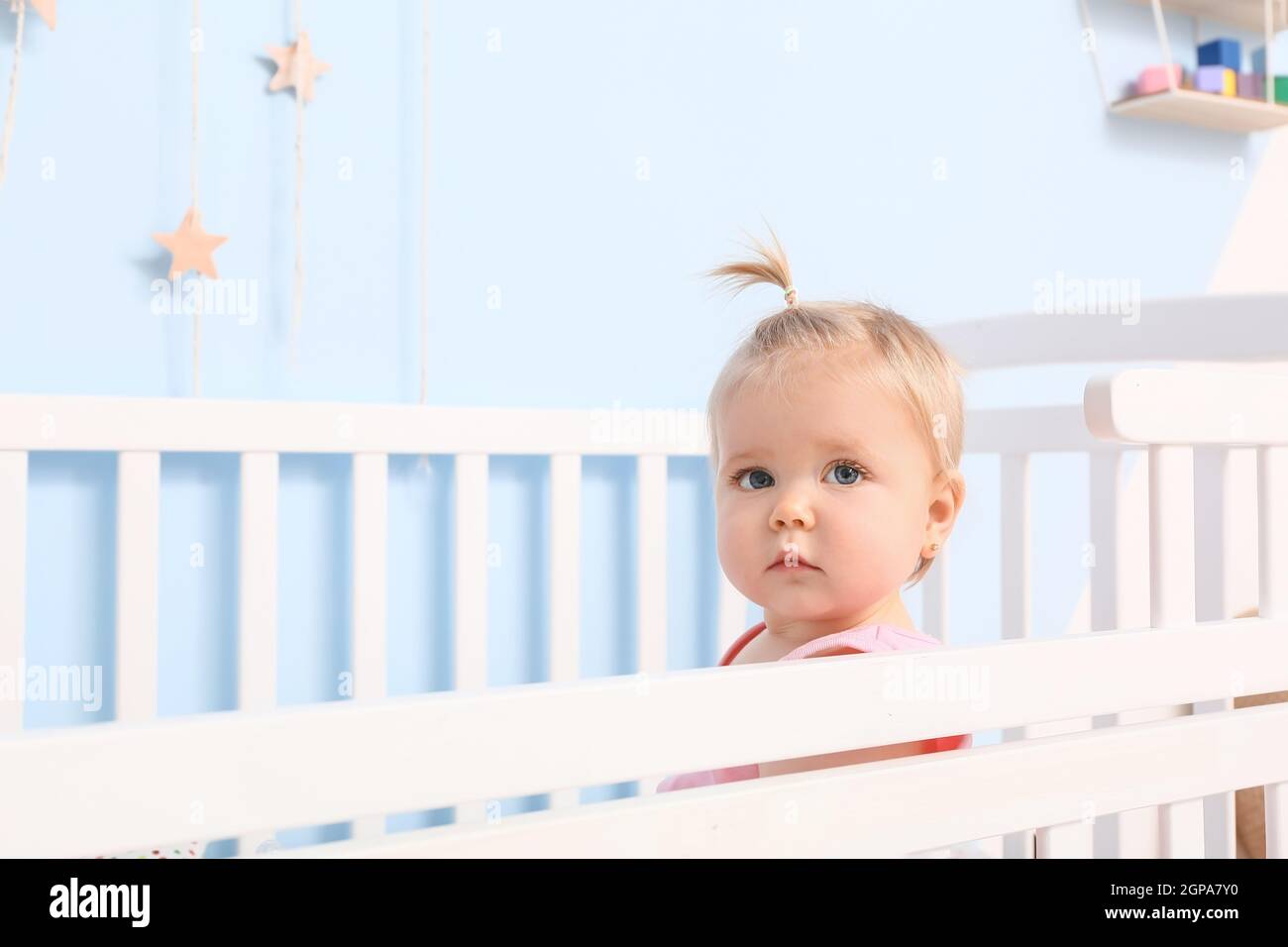 Cute baby girl in cot at home Stock Photo - Alamy