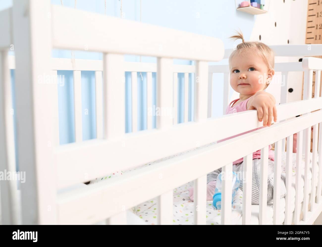 Cute baby girl in cot at home Stock Photo - Alamy