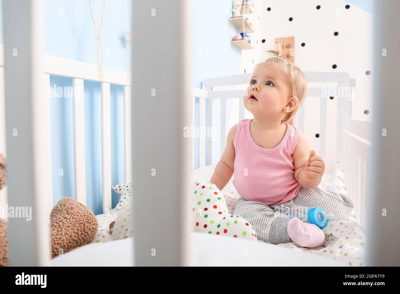 Cute baby girl with bottle of water in cot Stock Photo - Alamy