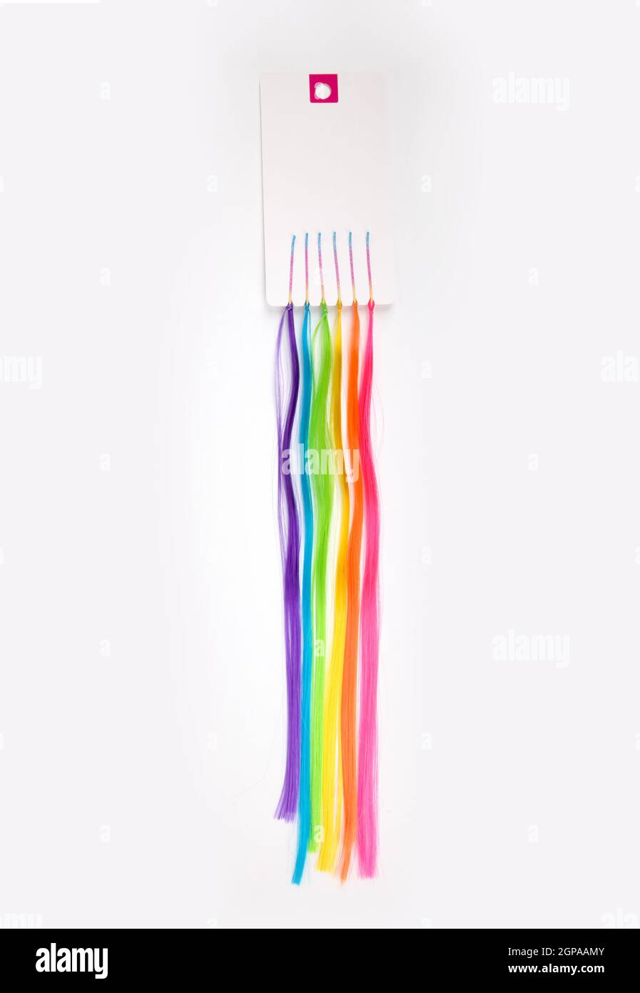 Artificial colored strands of hanging on a paper label with hairpins ...