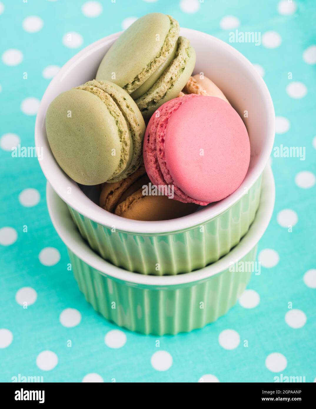 Sweet Macarons with green bowls and green fabric background Stock Photo ...