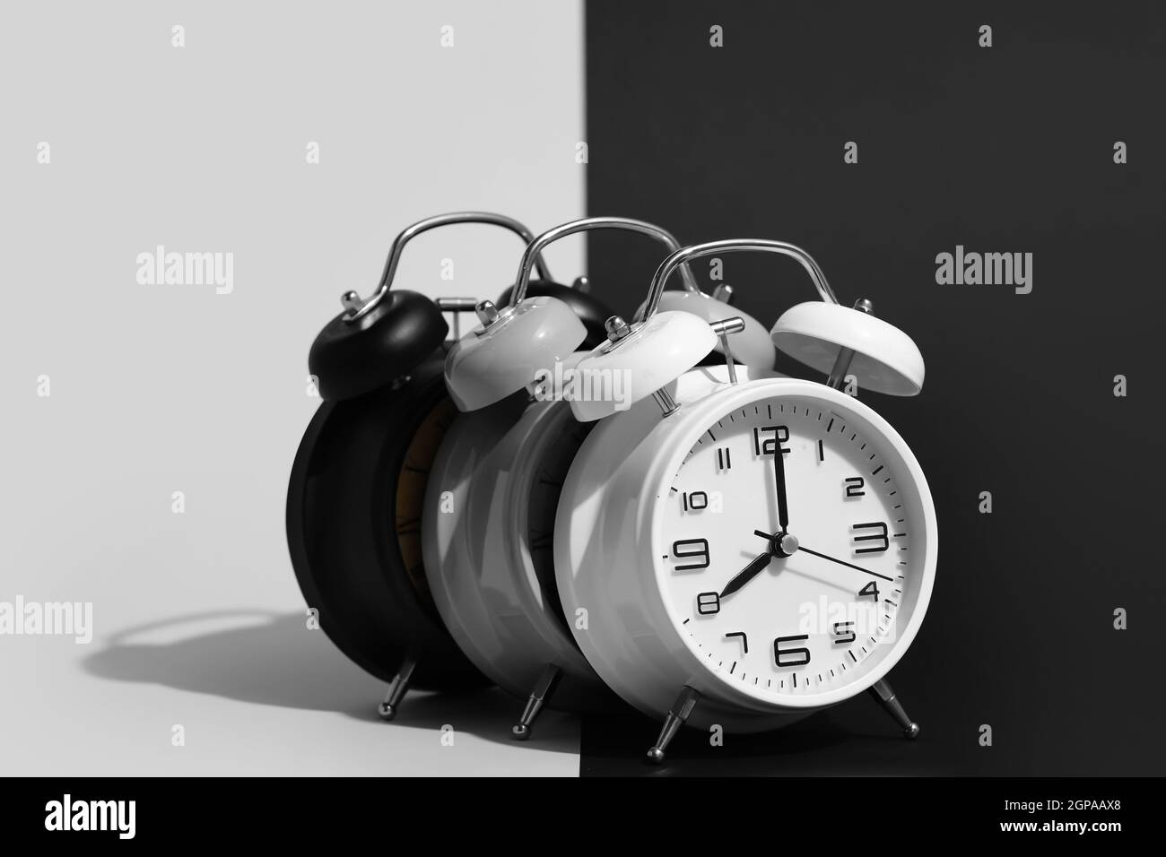 Retro alarm clocks in row on black and white background Stock Photo - Alamy