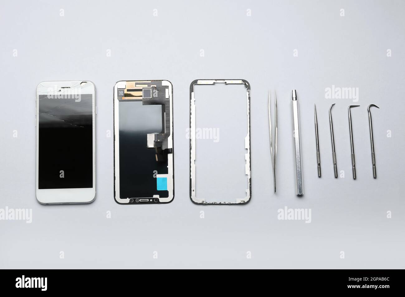 Broken mobile phone, display module, glass and technician tools on ...