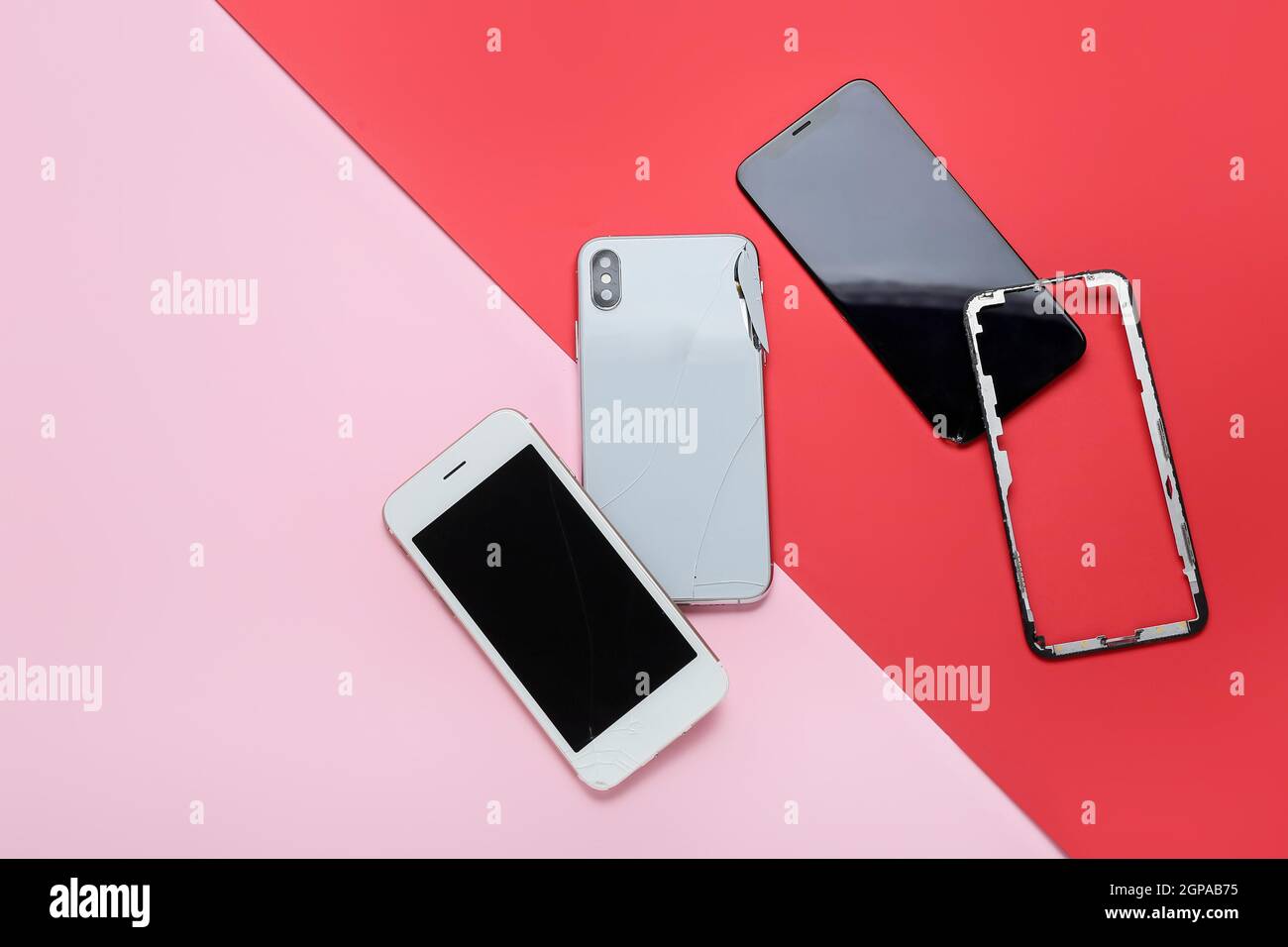Damaged mobile phones, display glass on pink and red background Stock ...