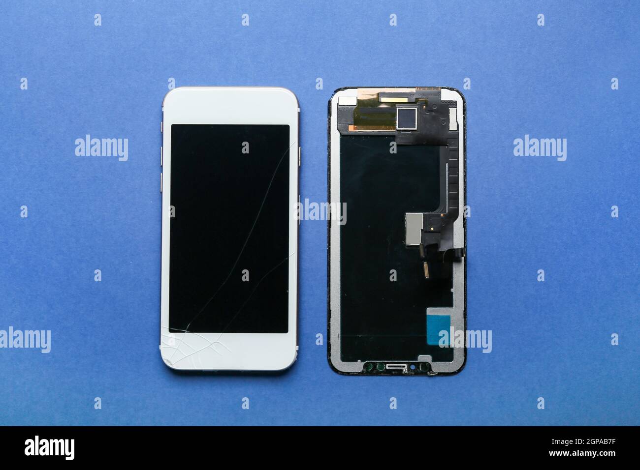 Mobile phone with damaged screen and display module on blue background ...