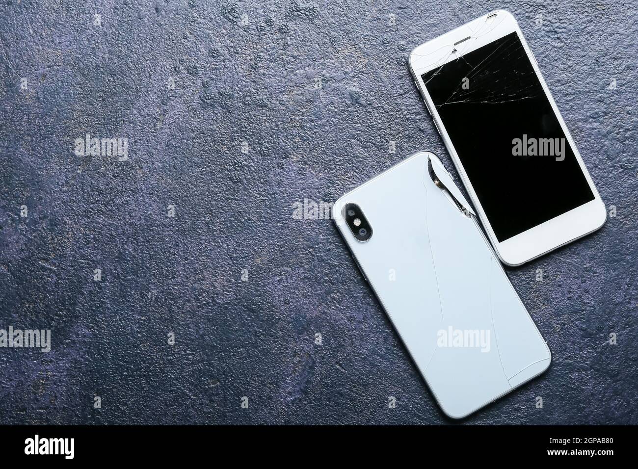 Broken mobile phones on dark background Stock Photo - Alamy