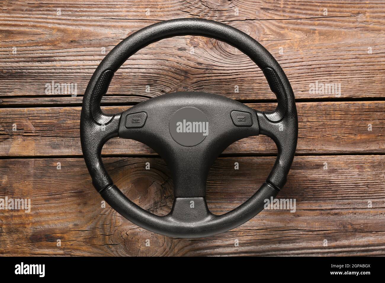 Modern steering wheel on wooden background Stock Photo - Alamy