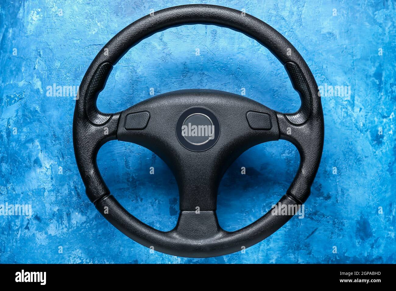 Modern steering wheel on blue background Stock Photo - Alamy