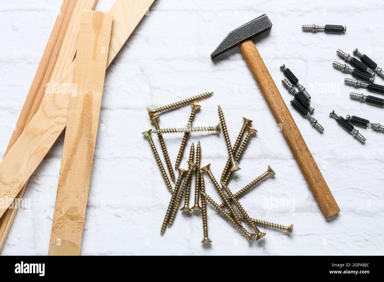 Wooden plank, hammer, screws and bolts on white brick background Stock ...