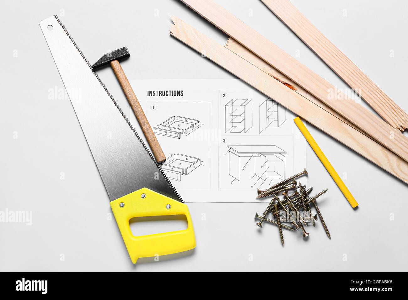 Furniture assembling instructions, wooden planks and tools on white ...