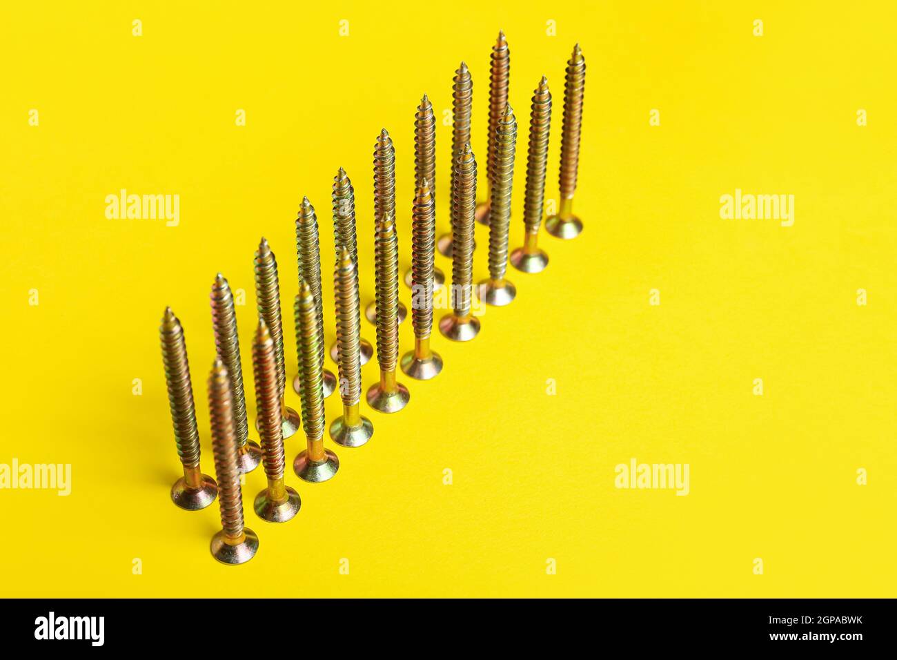 Line of wood screws on yellow background Stock Photo - Alamy