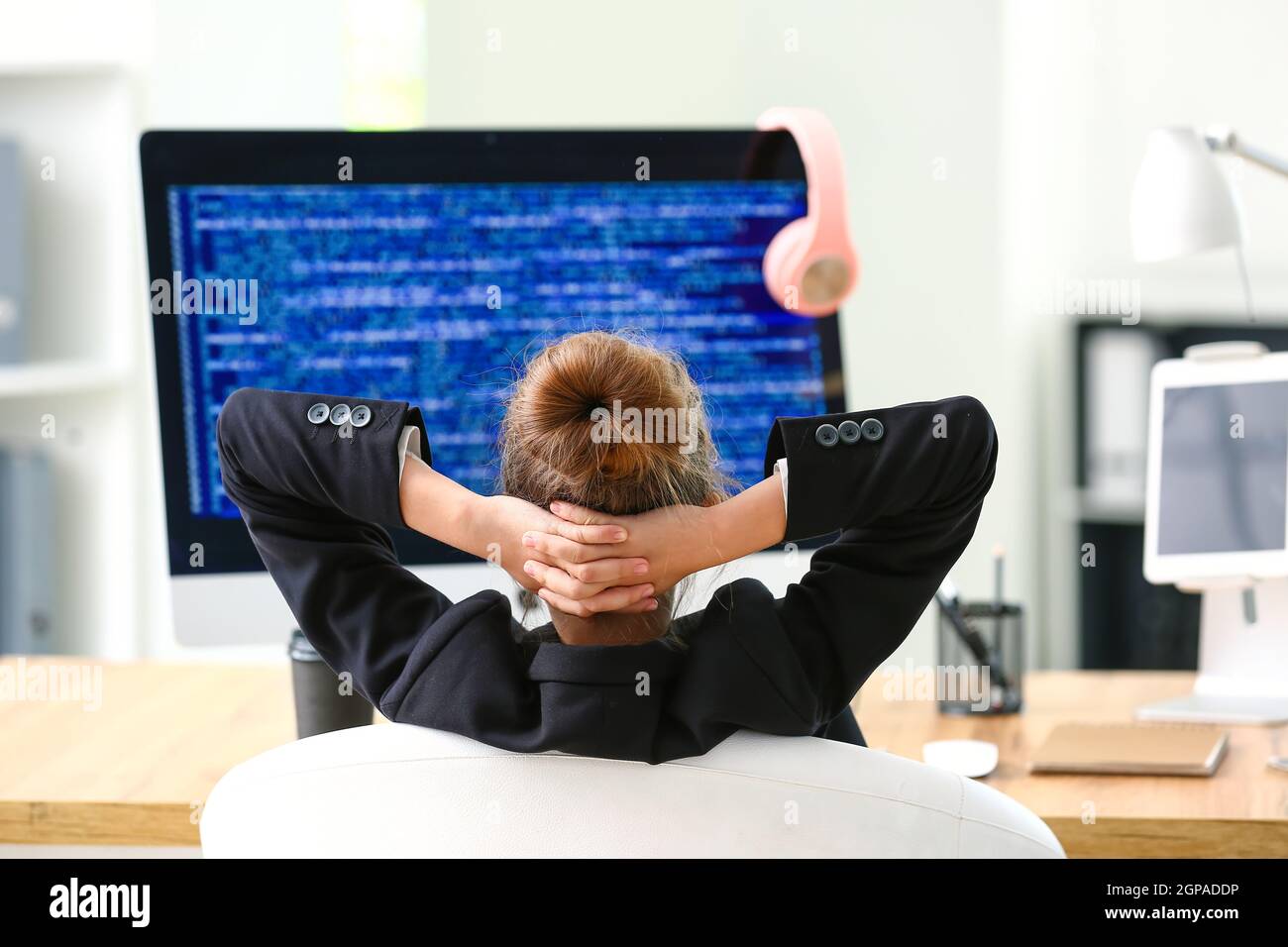 Cute little programmer at table in office Stock Photo - Alamy
