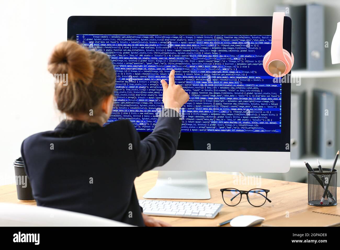 Cute little programmer at table in office Stock Photo - Alamy