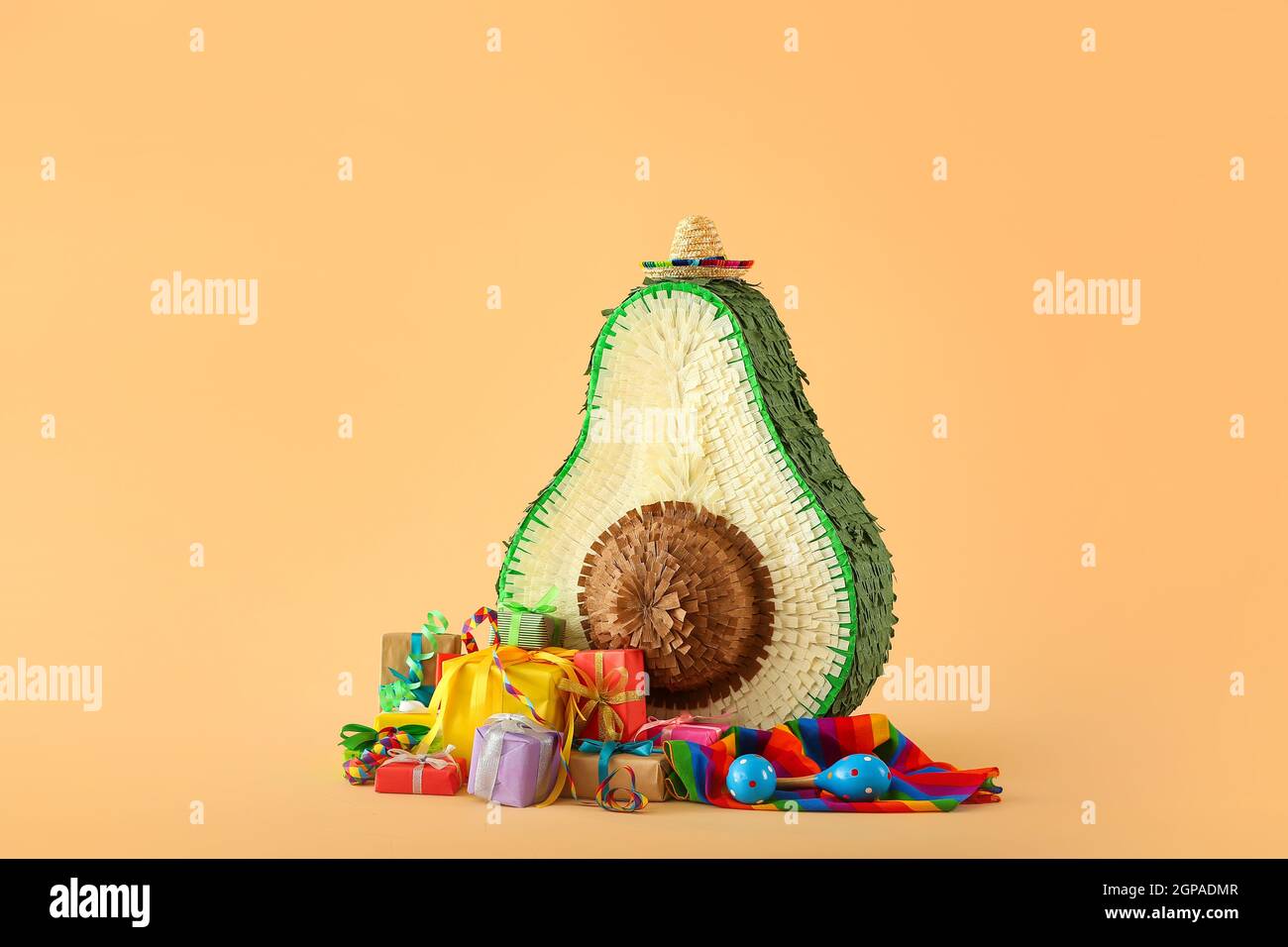 Mexican pinata with different gifts and maracas on color background ...