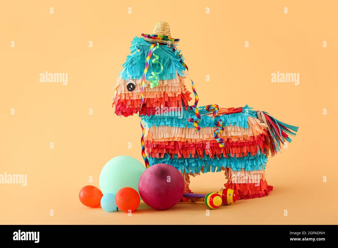 Mexican pinata with sombrero hat, maracas and balloons on color ...