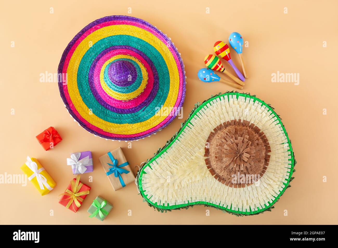 Mexican pinata with sombrero hat, maracas and gifts on color background ...