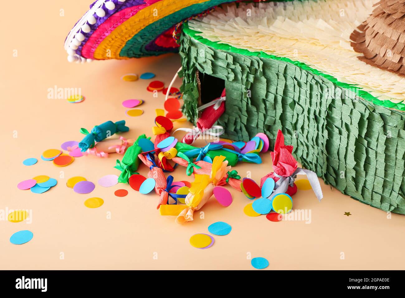 Mexican pinata in shape of avocado, sombrero hat and confetti on color ...
