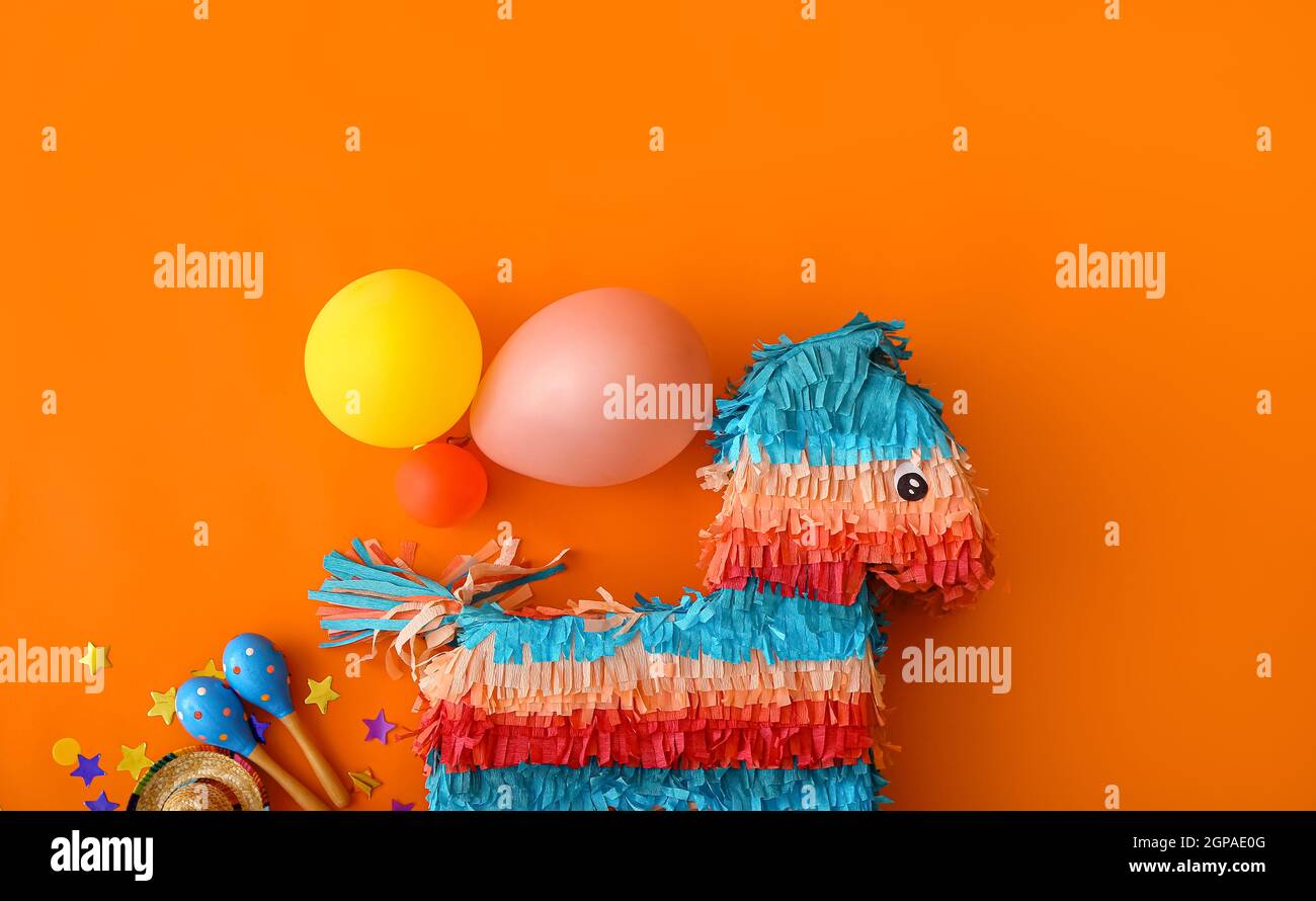Mexican pinata with sombrero hat, balloons and maracas on color ...