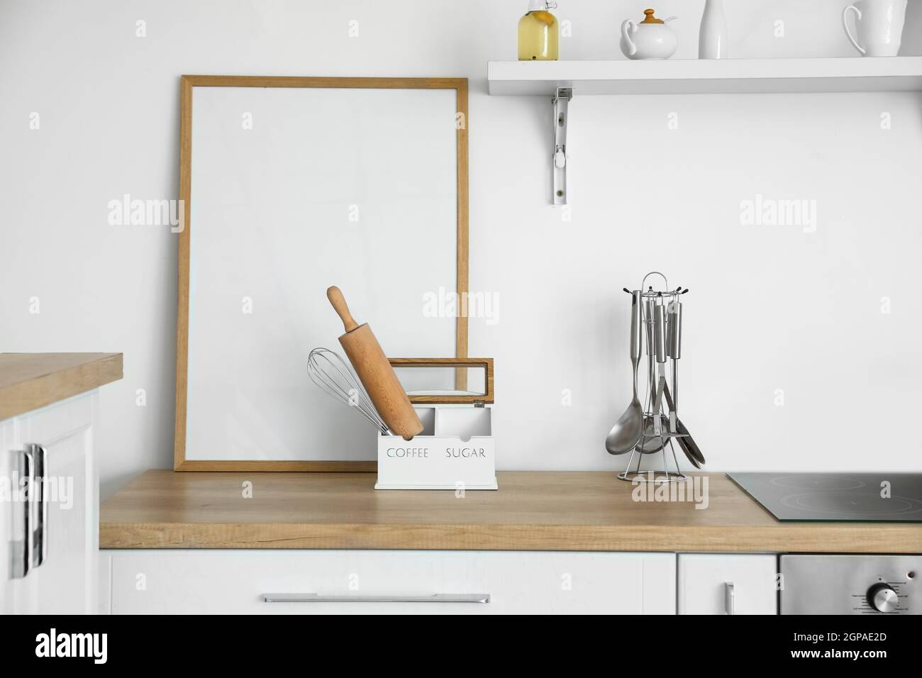 Blank poster frame on kitchen counter near light wall Stock Photo - Alamy