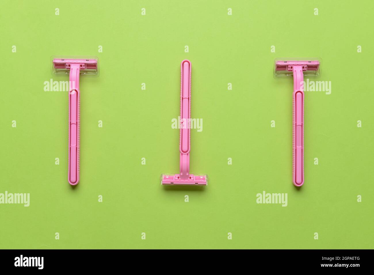 Safety razors on green background Stock Photo - Alamy