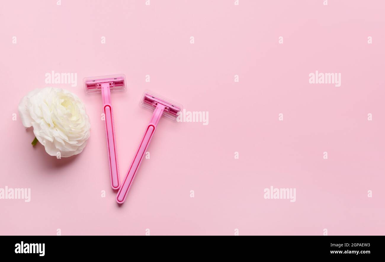 Safety razors and flower on pink background Stock Photo - Alamy
