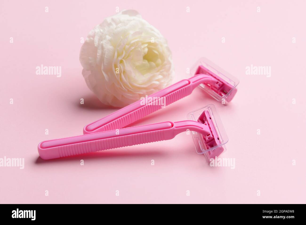 Safety razors and flower on pink background Stock Photo - Alamy