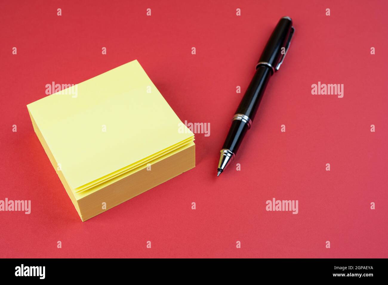 some yellow adhesive notepapers block with a pen Stock Photo - Alamy