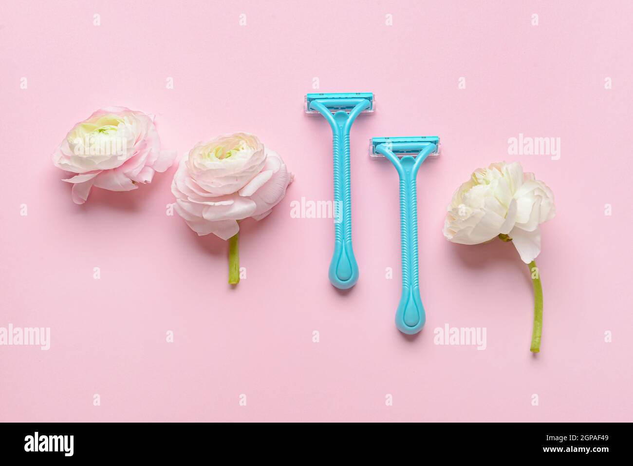 Safety razors and flowers on pink background Stock Photo - Alamy