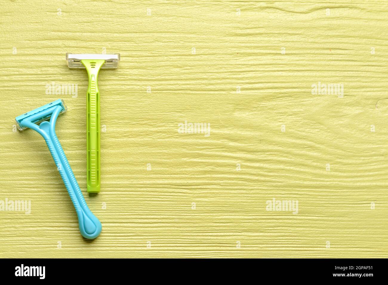 Safety razors on color wooden background Stock Photo - Alamy