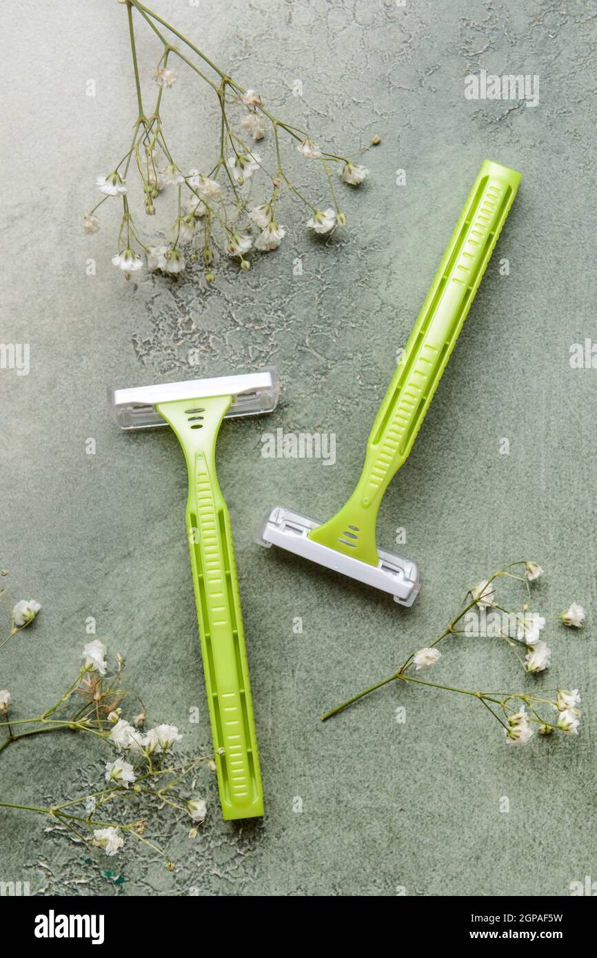 Safety razors and flowers on grunge background Stock Photo - Alamy