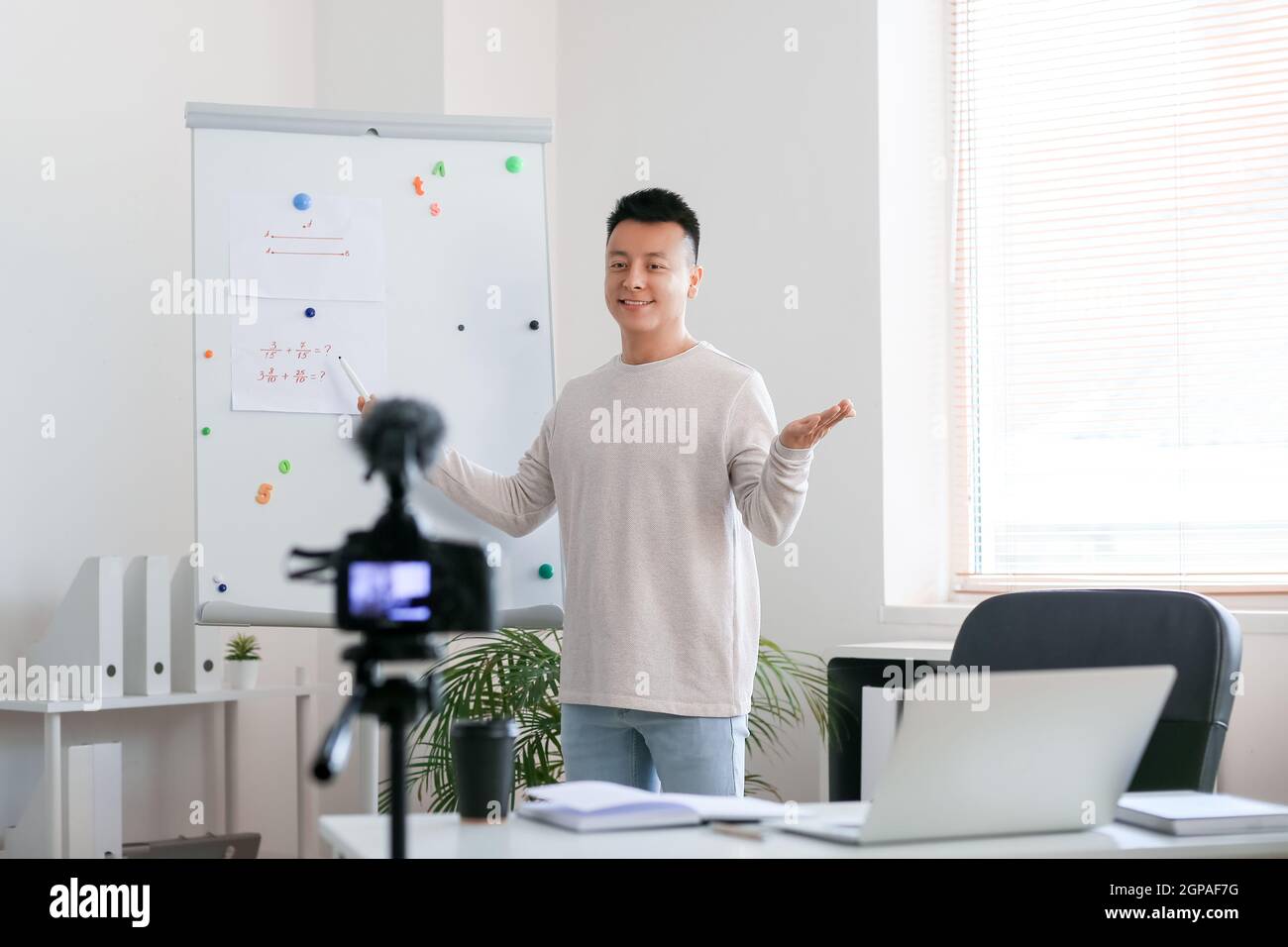 Asian teacher recording video for his students in classroom Stock Photo ...