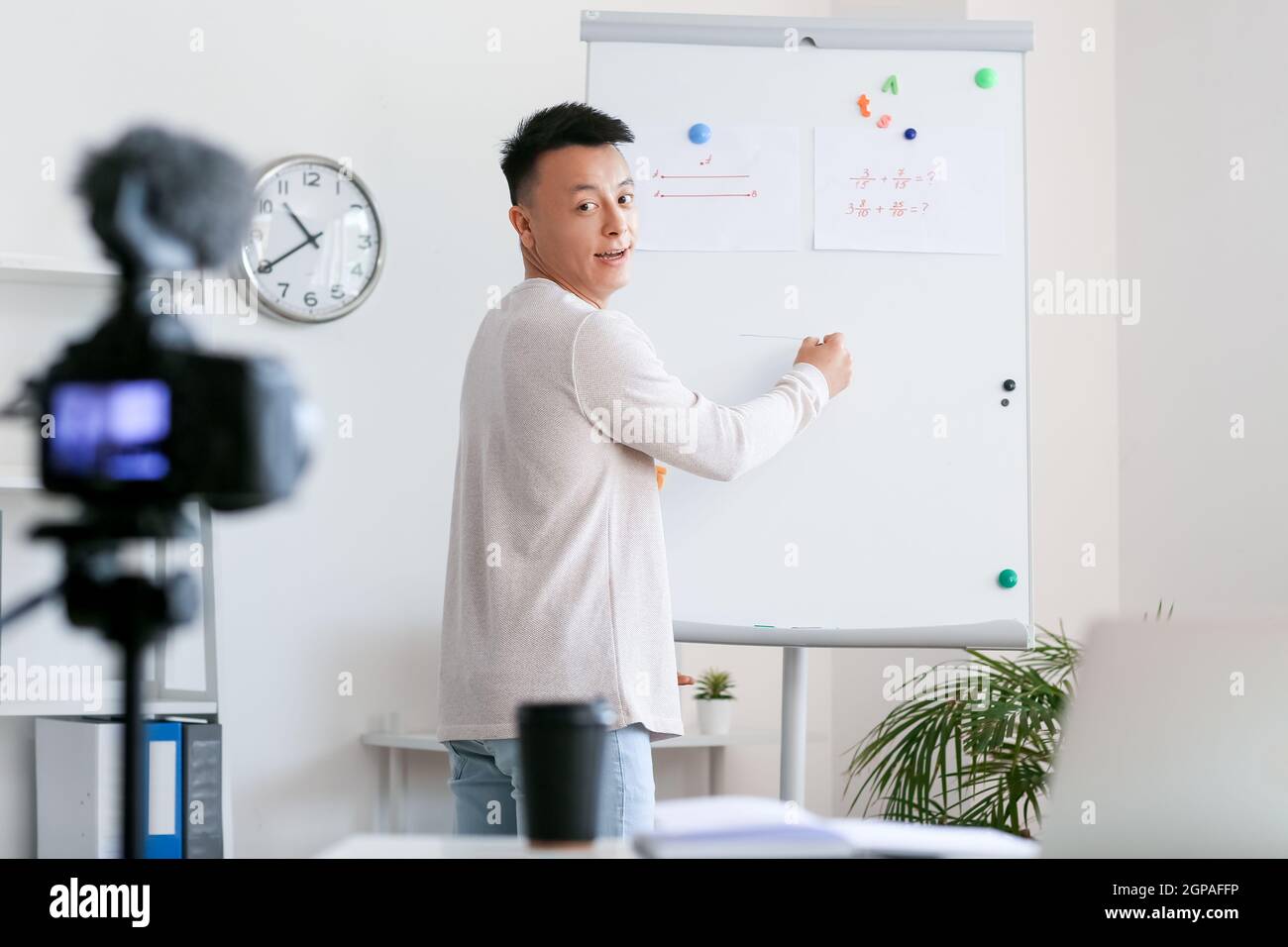 Asian teacher recording video for his students in classroom Stock Photo ...