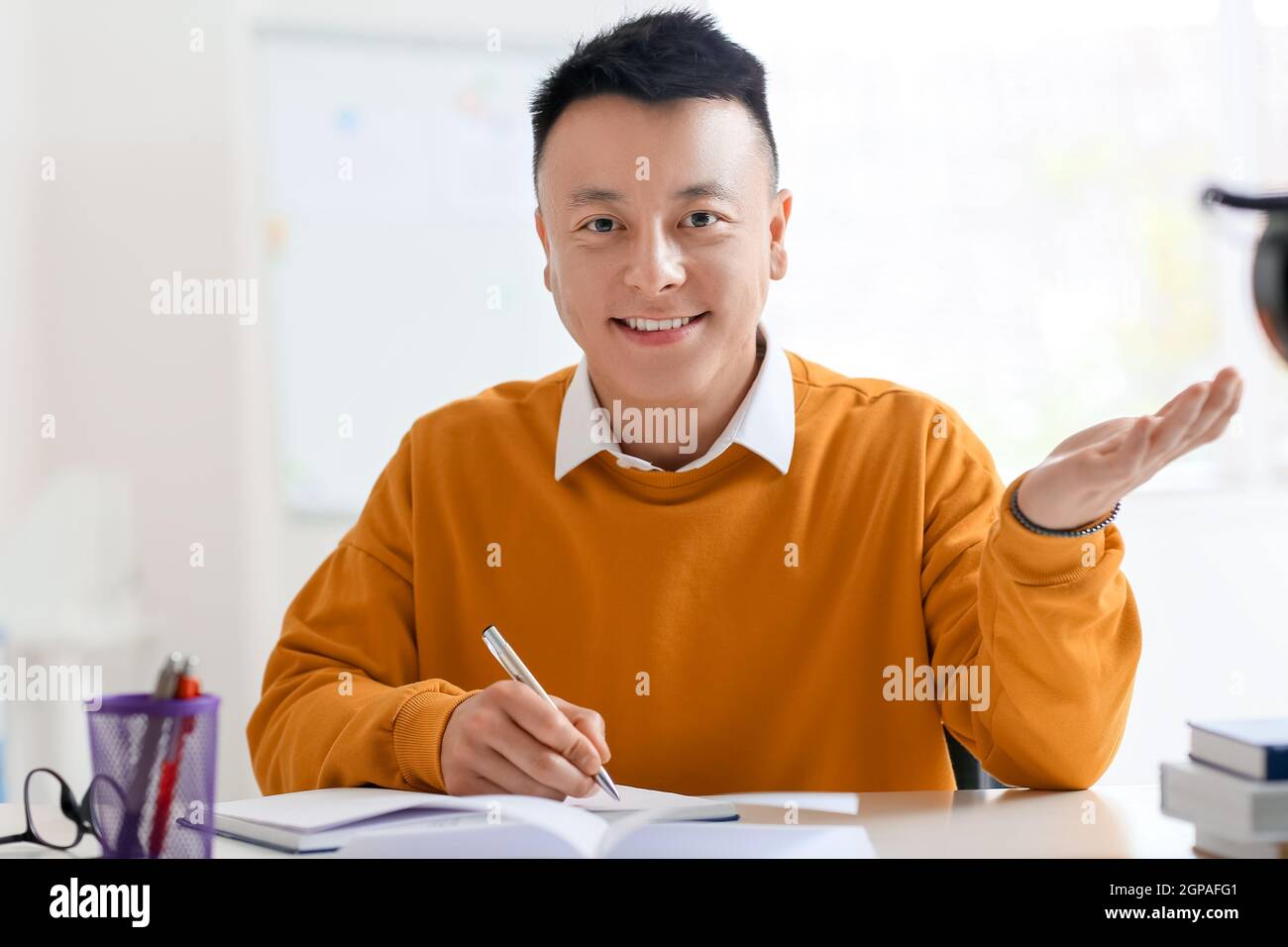 Asian teacher conducting lesson in classroom Stock Photo - Alamy