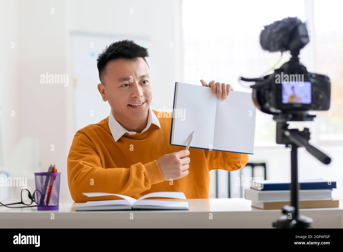 Asian teacher recording video for his students in classroom Stock Photo ...