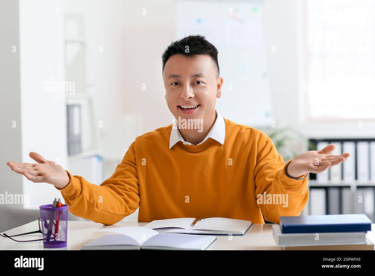 Asian teacher conducting lesson in classroom Stock Photo - Alamy