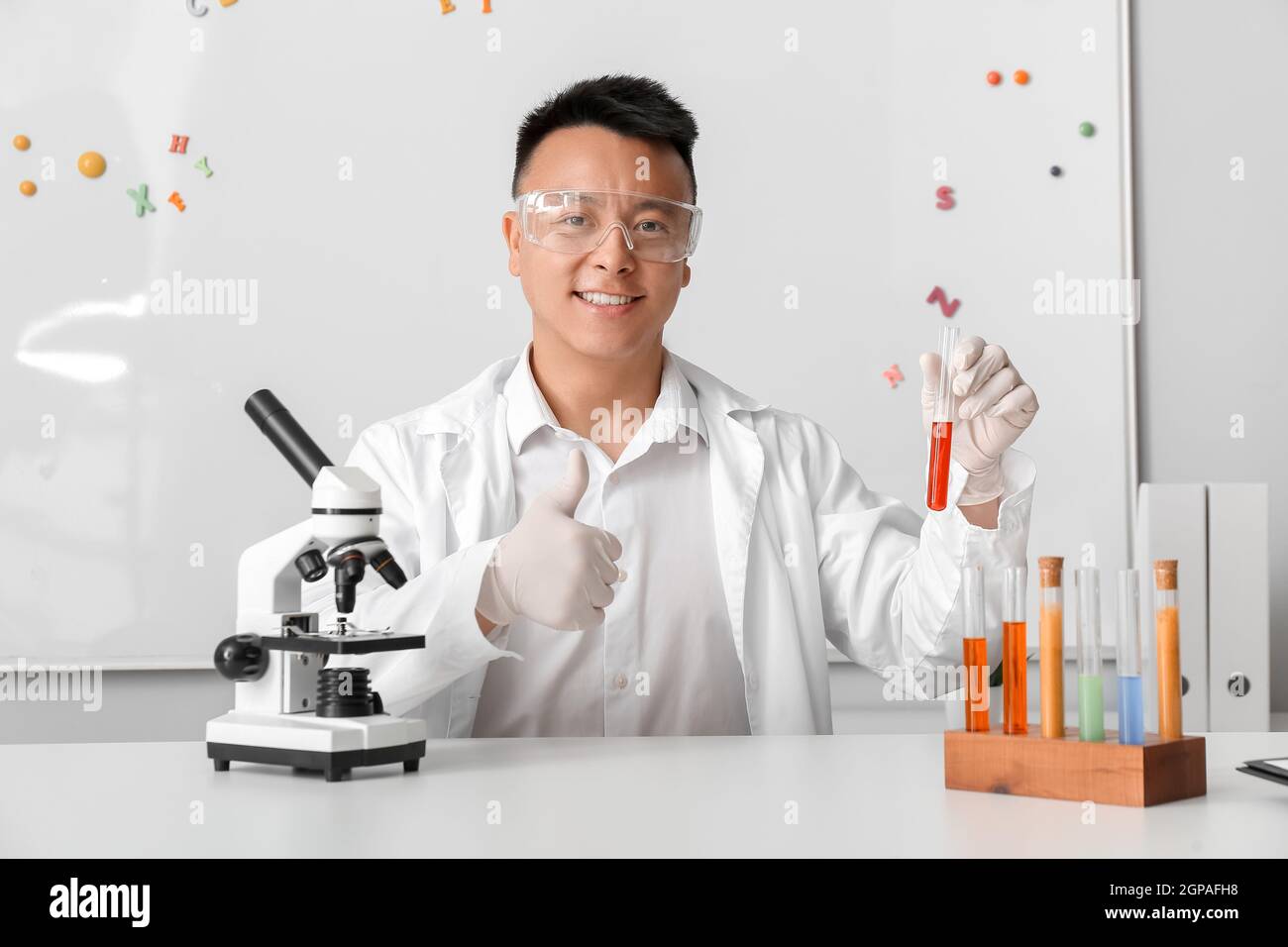Asian teacher conducting chemistry lesson Stock Photo - Alamy