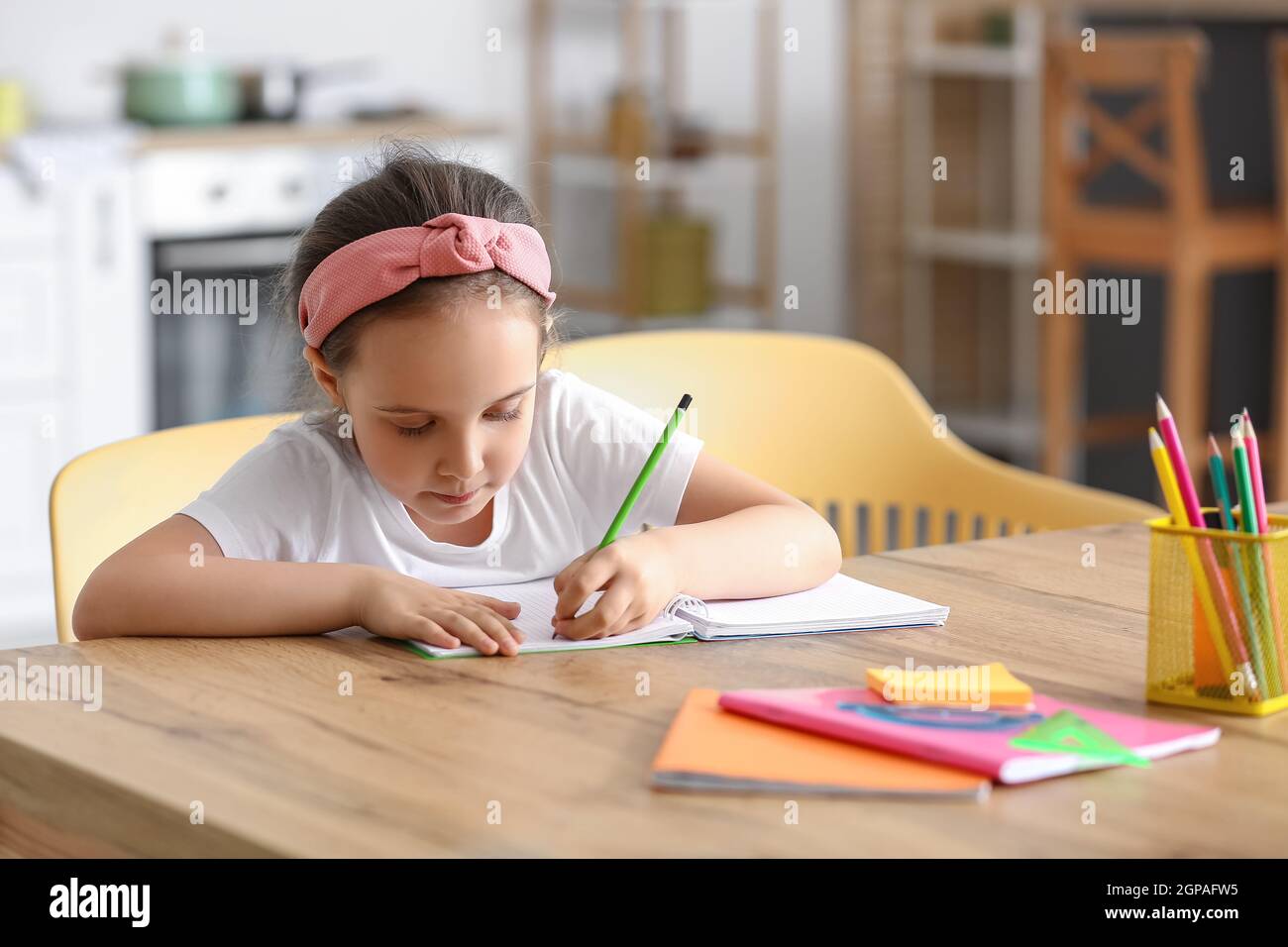 Little girl doing lessons at home Stock Photo - Alamy