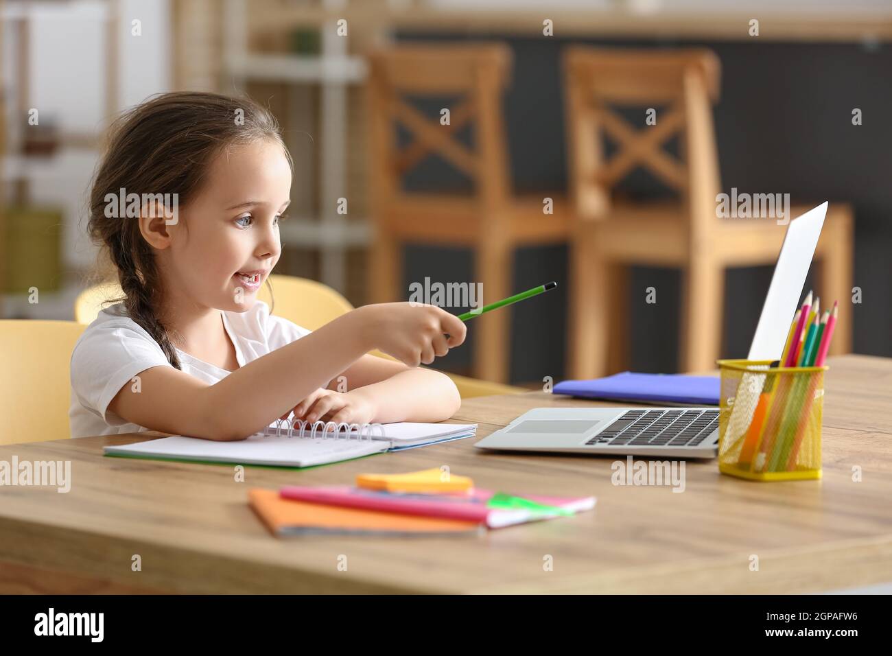 Little girl doing lessons online at home Stock Photo - Alamy